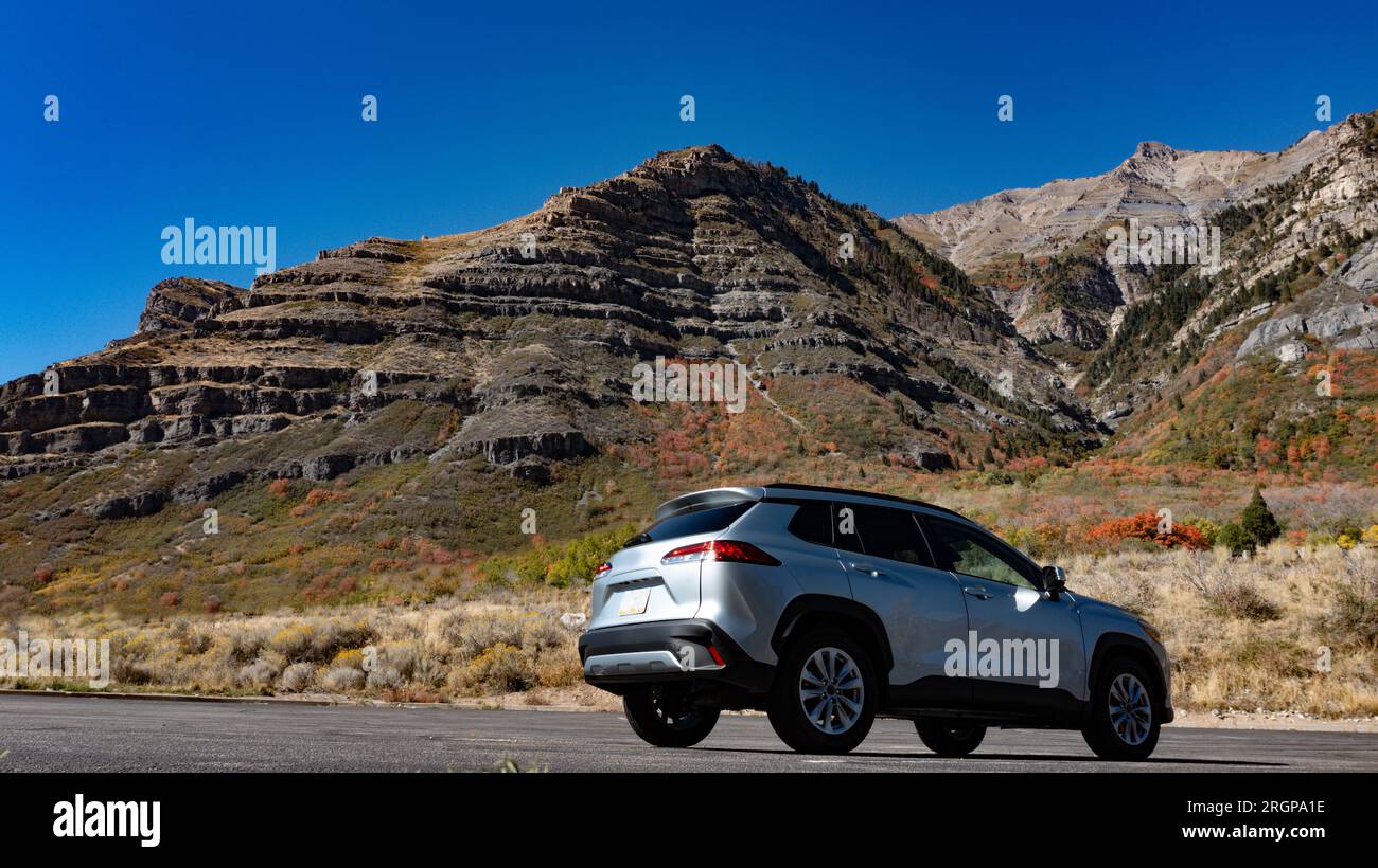 Small silver SUV in front of fall mountain range in Utah explore Stock ...