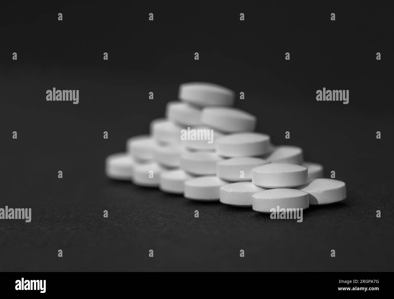 White tablets close-up on a black background with copy space. The ...