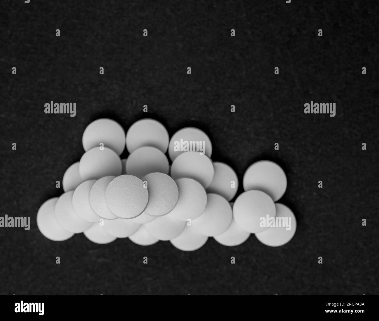 Medication concept. Medical round white tablets closeup on black ...