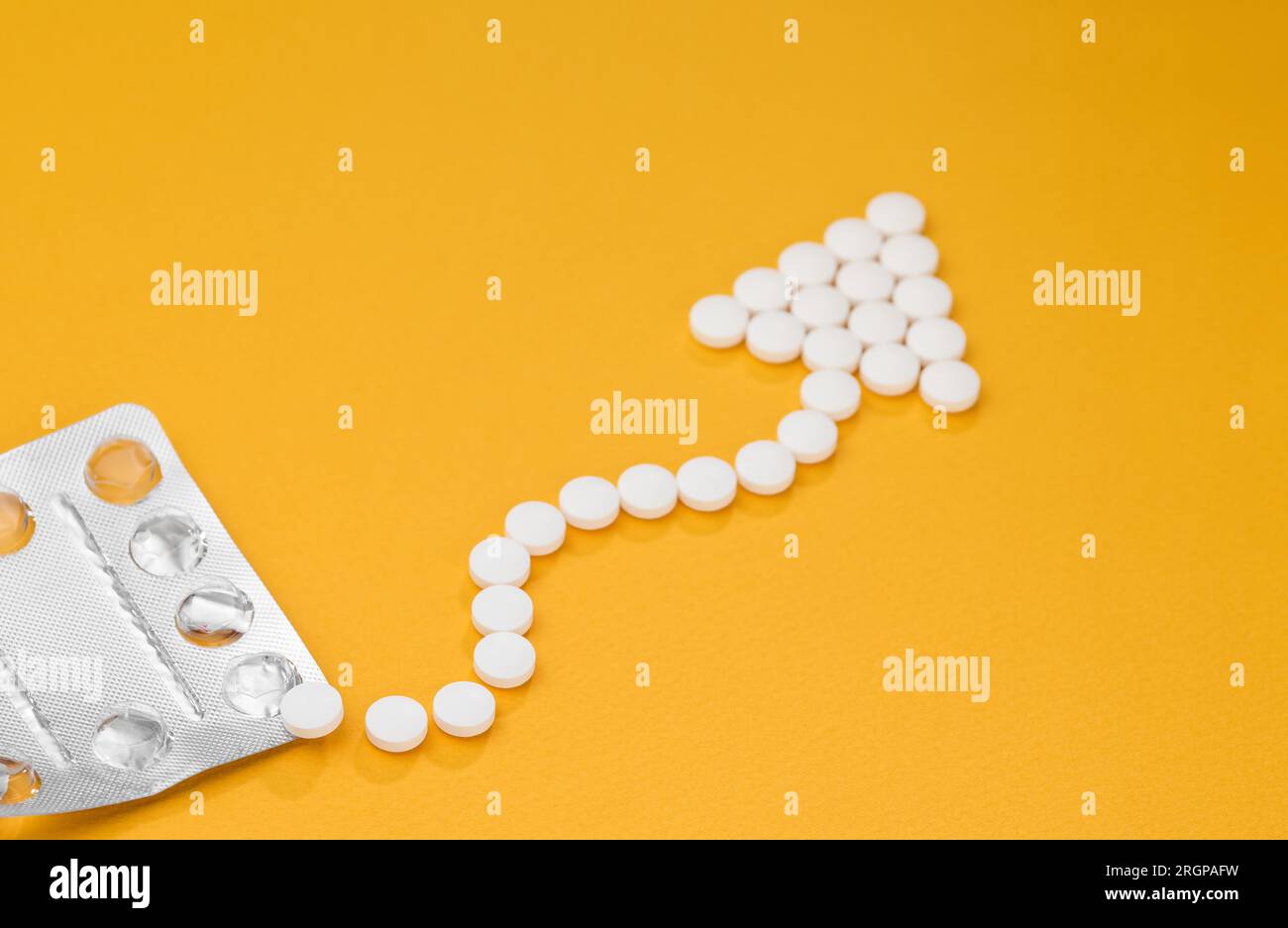 Medical pills flow from a blister pack and form an arrow shape on a ...