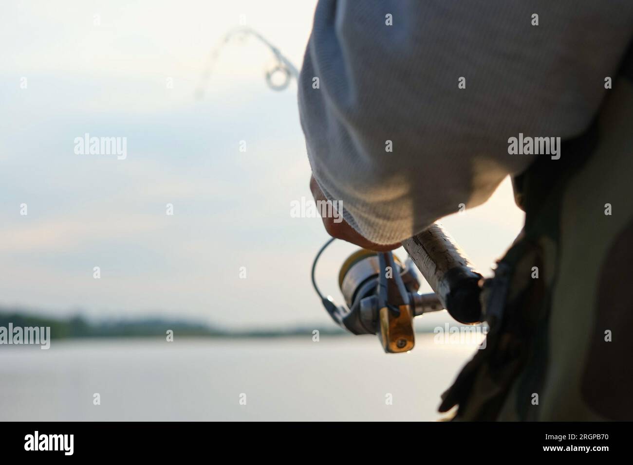 Old man fishing. Senior gray haired fisherman throws a spinning from ...
