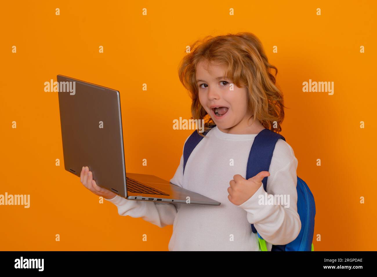 Smart child, clever school kid. School child with thumb up using laptop ...