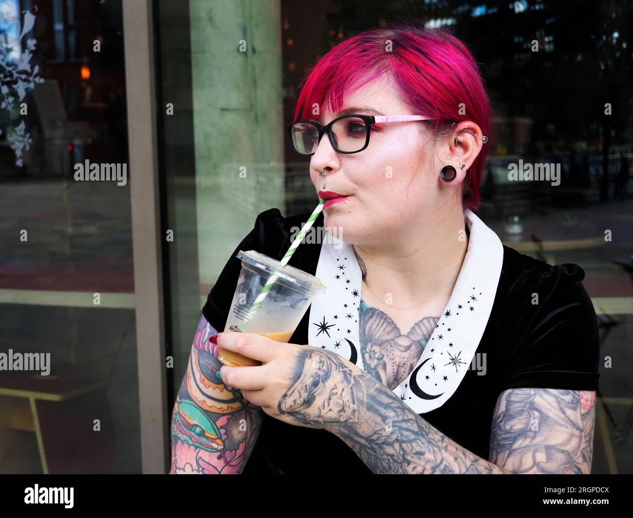 Woman in her mid twenties with dyed red hair and tattoos wearing ...