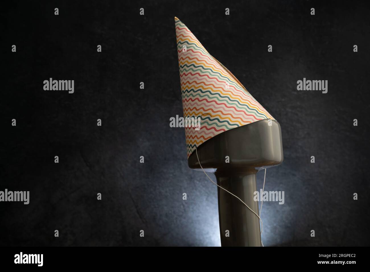 Heavy gym dumbbell in a colorful Birthday party hat. Exercise equipment ...