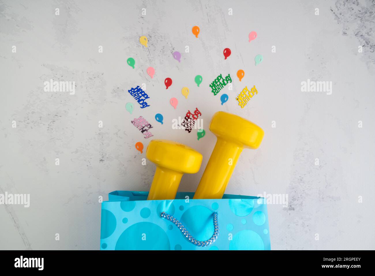 Gym dumbbells in a gift bag with Happy Birthday decorations. Party ...