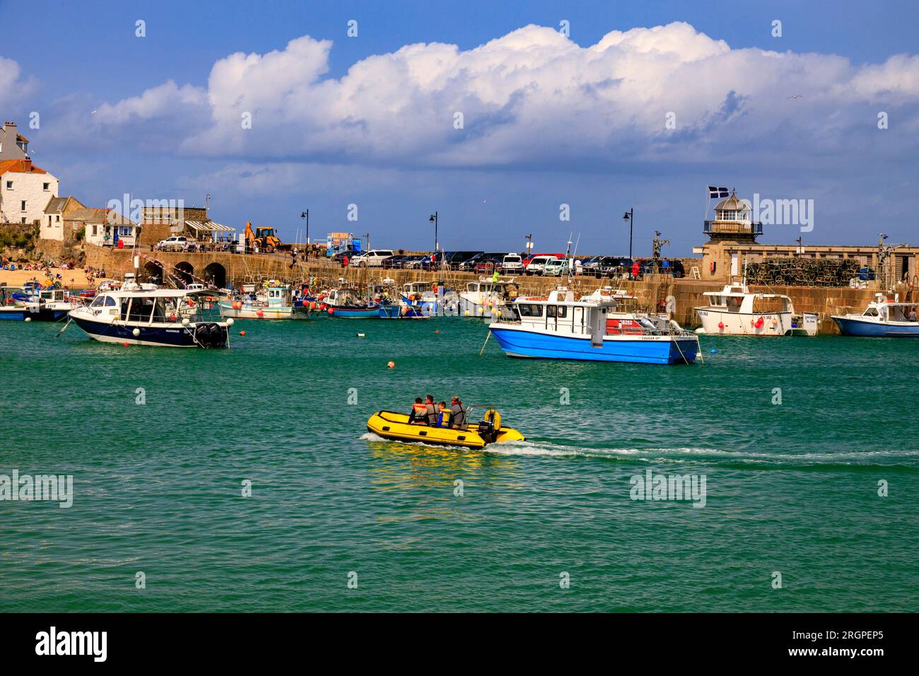 An inflatable rib enters the harbour at St Ives past the lighthouse on ...