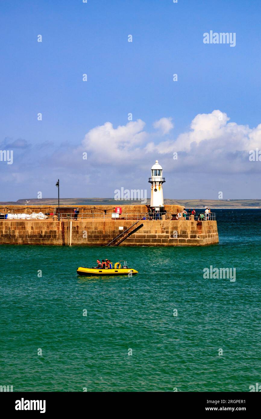 An inflatable rib enters the harbour at St Ives past the lighthouse on ...