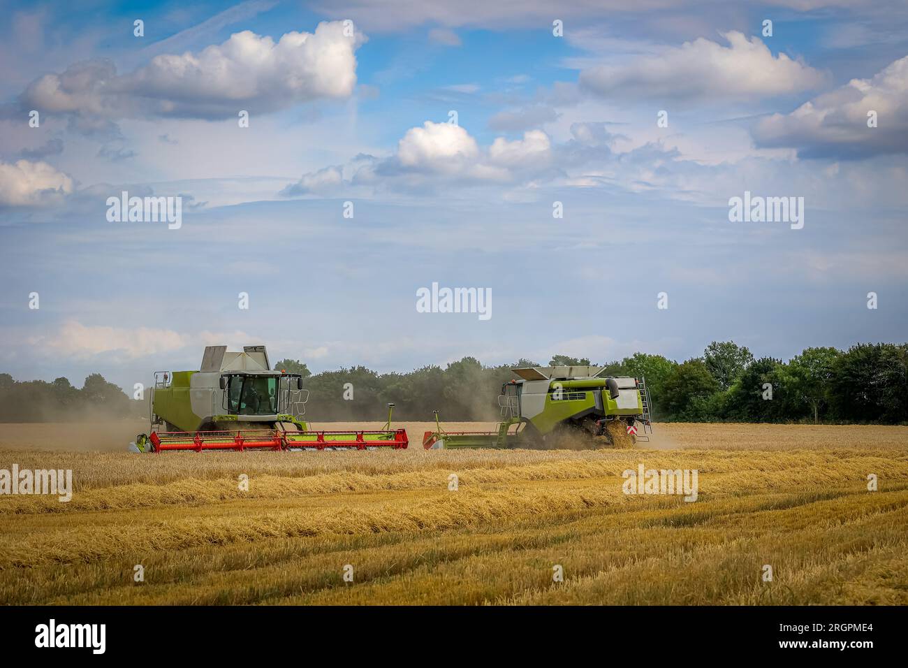 A close up view of two combine harvesters traveling towards each other ...