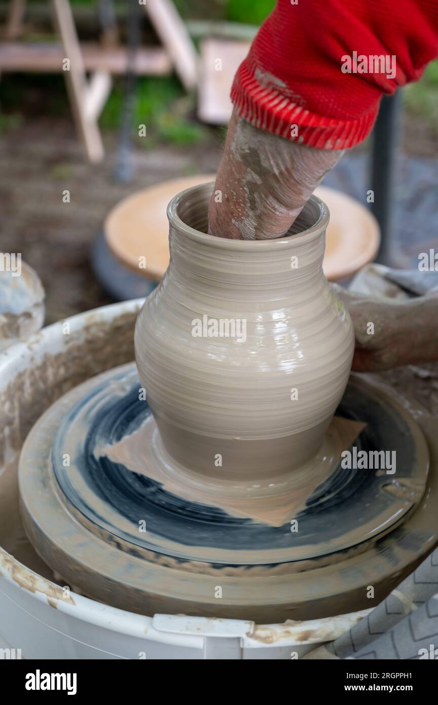 Making of mud pot on potters wheel during workshop outdoor in ...
