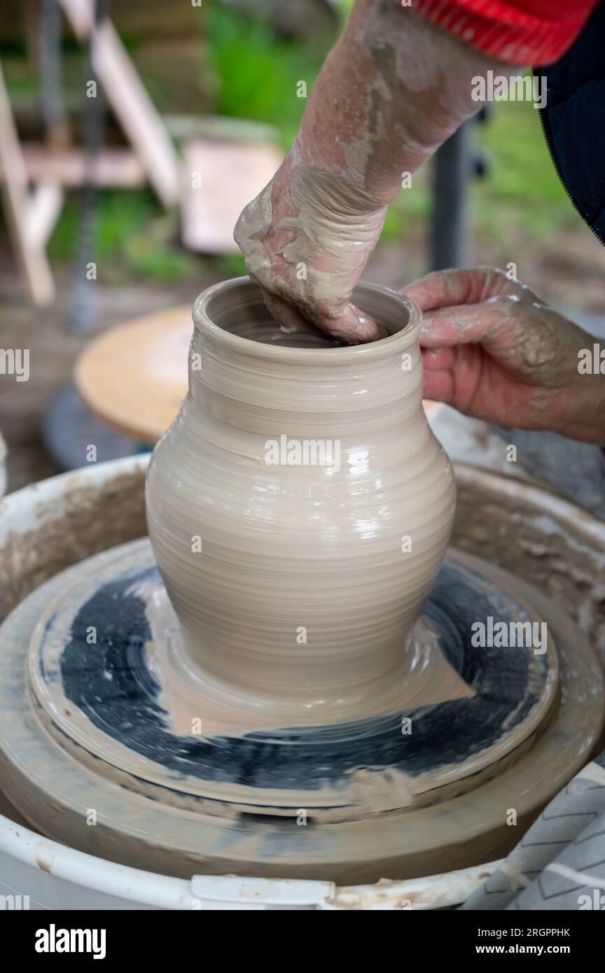 Making of mud pot on potters wheel during workshop outdoor in ...