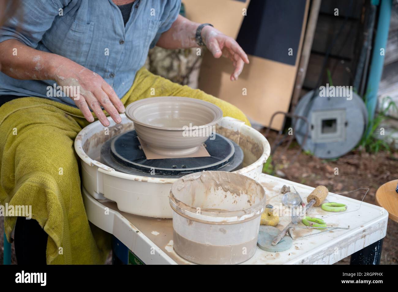 Making of mud pot on potters wheel during workshop outdoor in ...