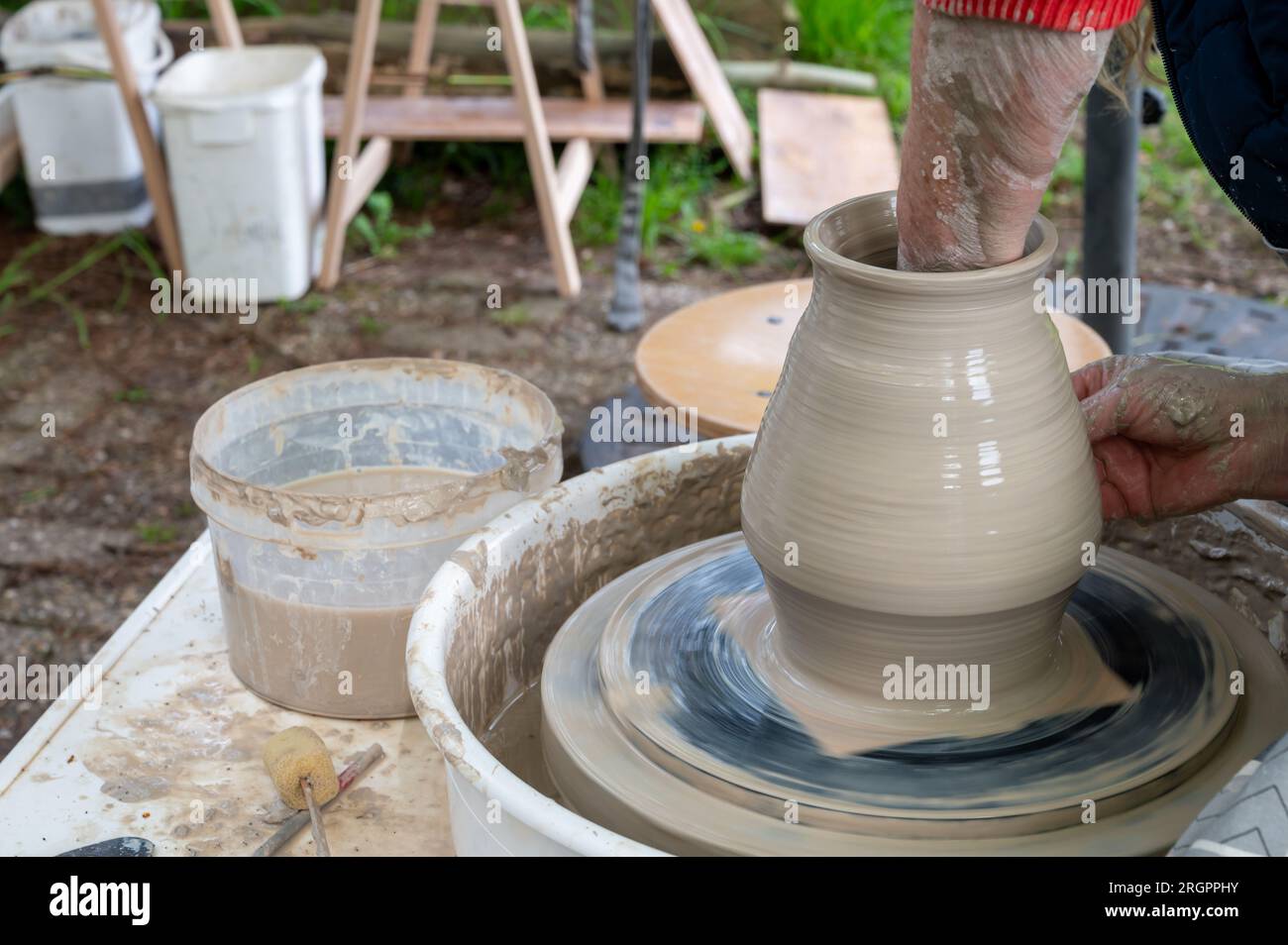 Making of mud pot on potters wheel during workshop outdoor in ...