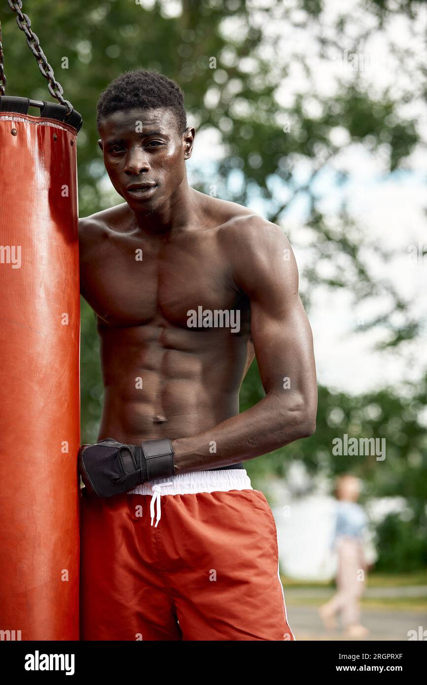 Front view of muscular black boxer punching towards camera with a deep ...