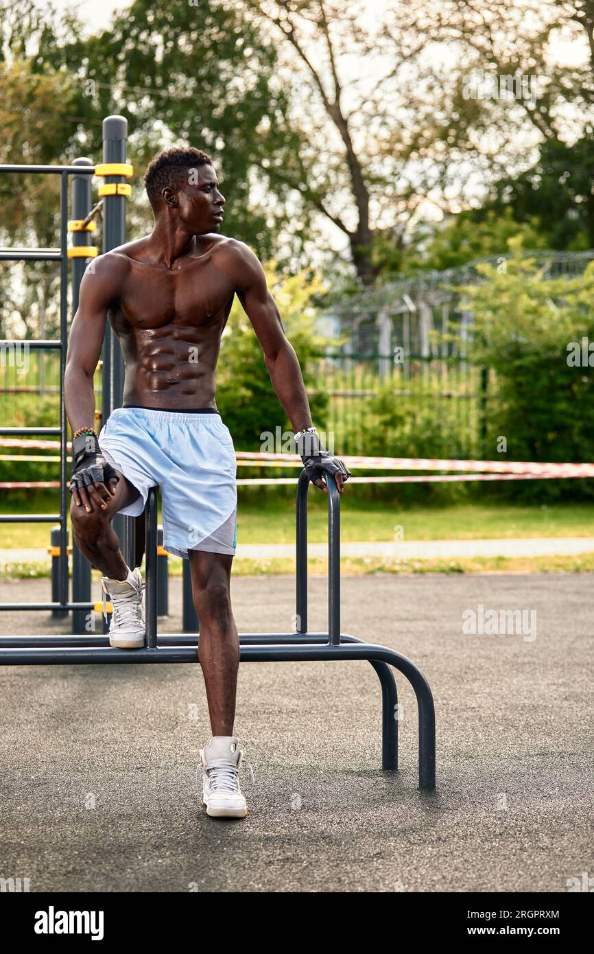 Muscular african man doing push ups against blue sky. Strong male ...