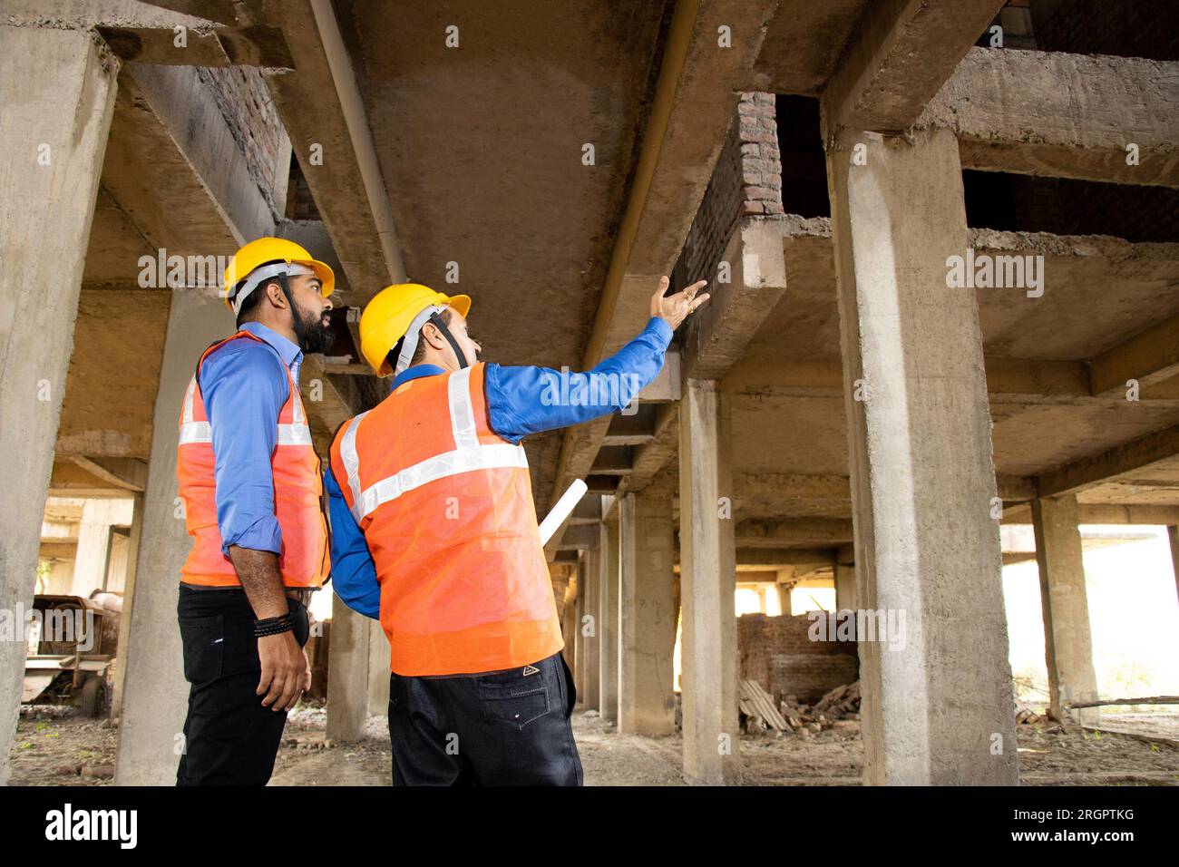 Two Indian female civil engineers or architect wearing helmet and vest ...