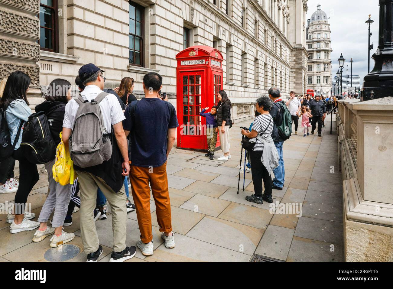 Visitors and tourists queue for a selfie with a red phone box in ...