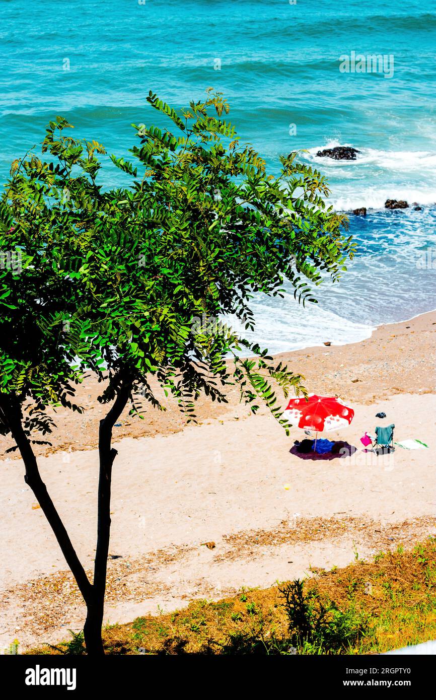 Camping chair with red umbrella on the beach with blue sea day noon ...