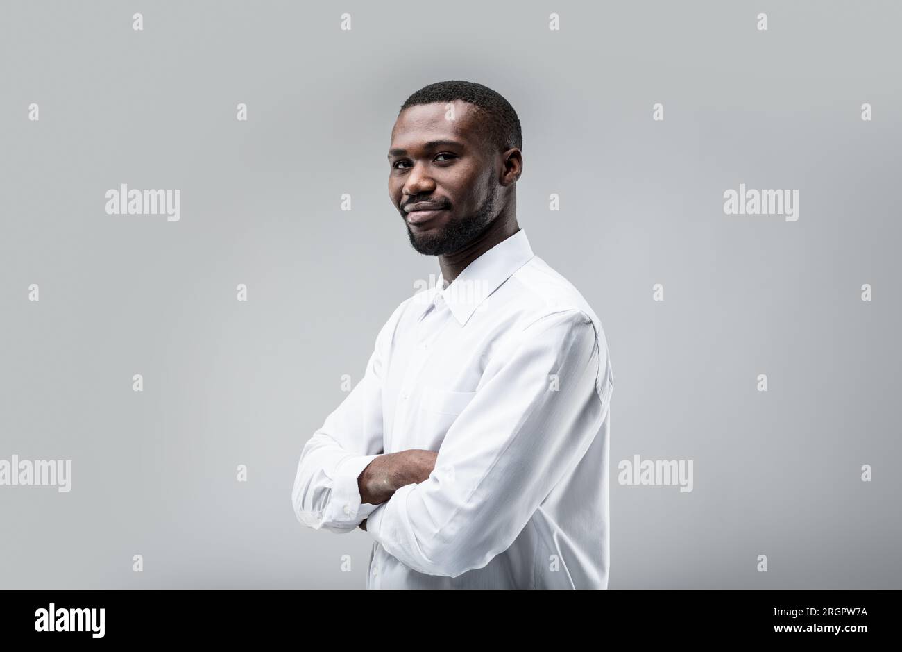 Black man, grey background, light reassuring smile with pride, short ...