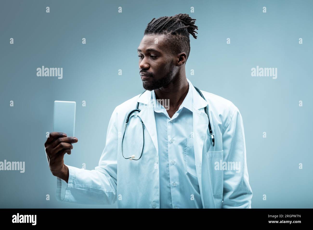 Black medical specialist demonstrates smartphone use. Modern ...