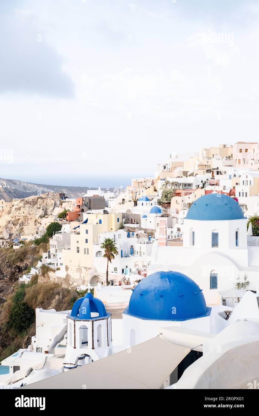Photograph of the famous blue domed churches in Oia, Santorini, amongst ...