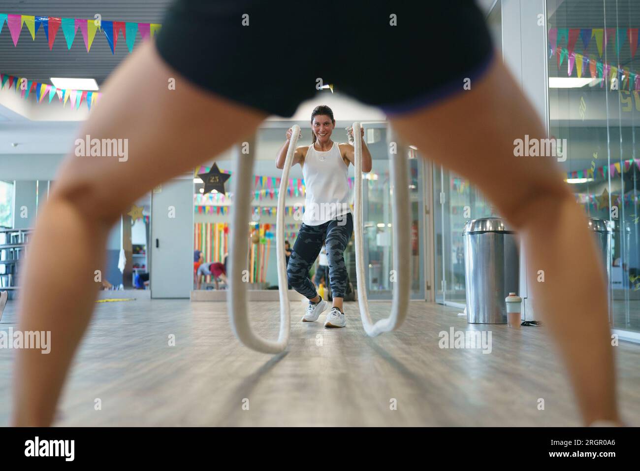 Young woman doing battle rope exercises Stock Photo - Alamy