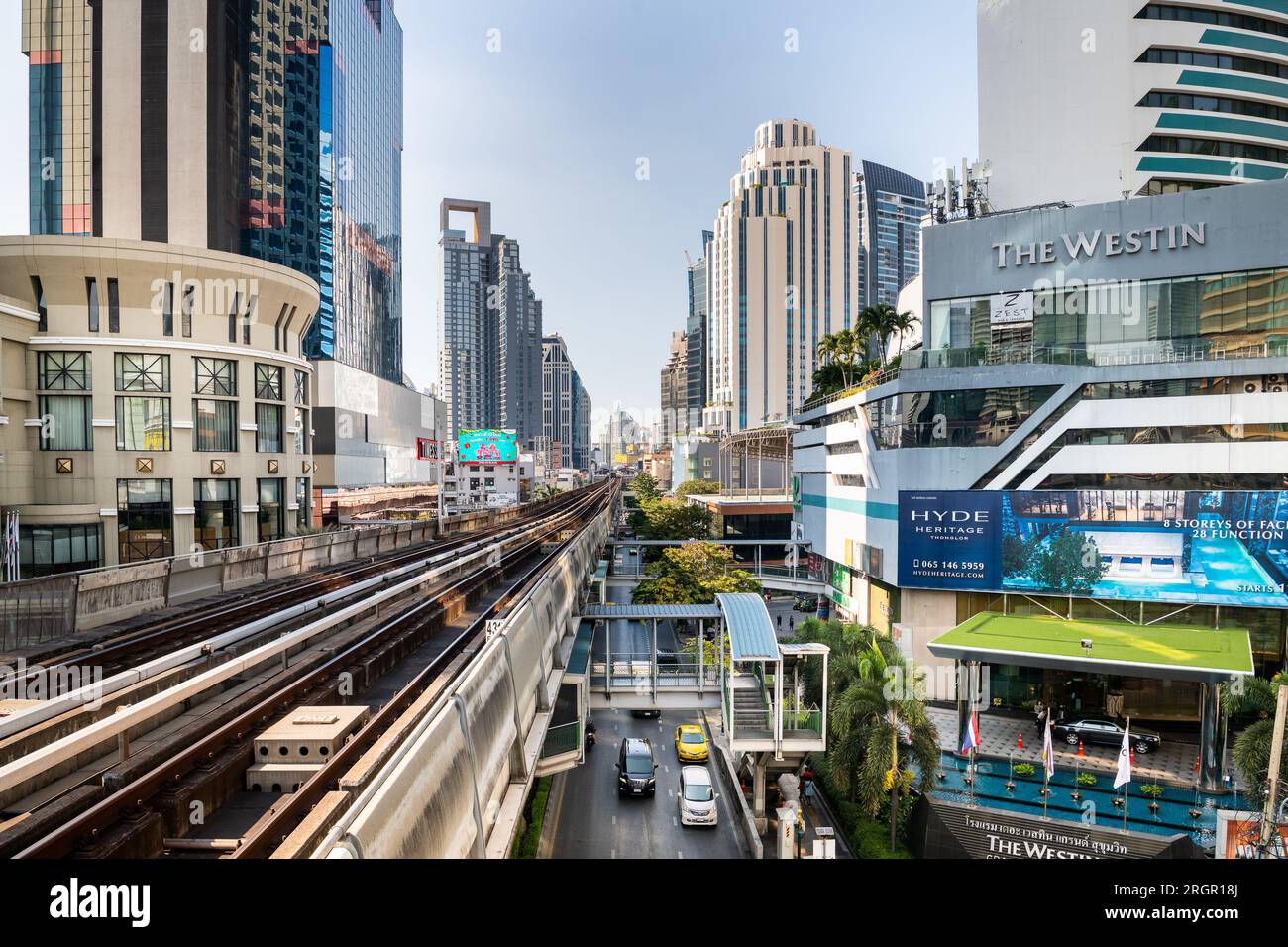 Sky trains come and go high above Sukhumvit Rd. at Asoke BTS sky train ...