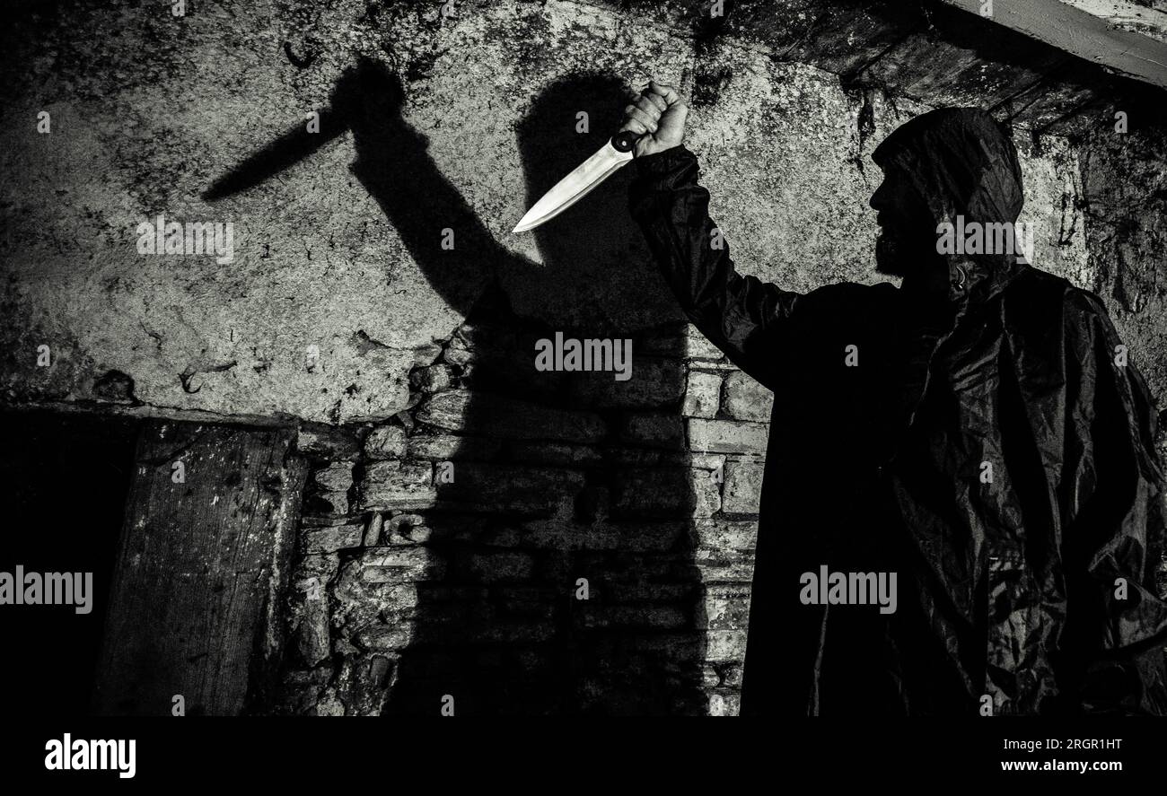 murderer with big knife and shadow horror scene Stock Photo - Alamy