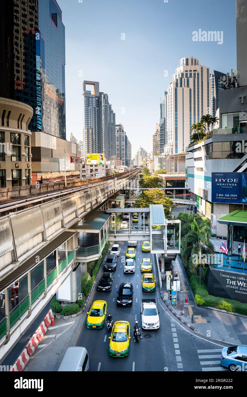 Sky trains come and go high above Sukhumvit Rd. at Asoke BTS sky train ...
