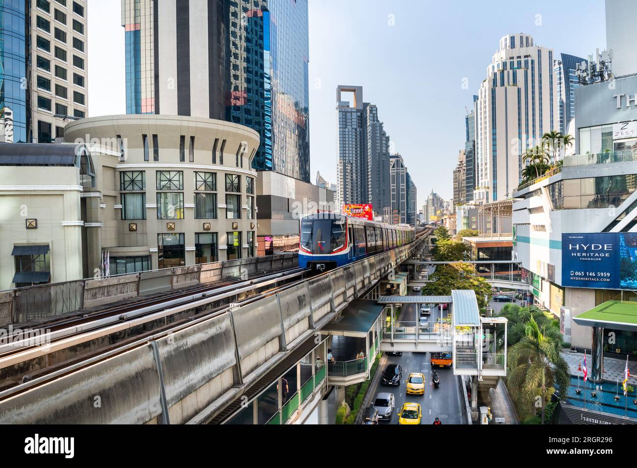 Sky trains come and go high above Sukhumvit Rd. at Asoke BTS sky train ...
