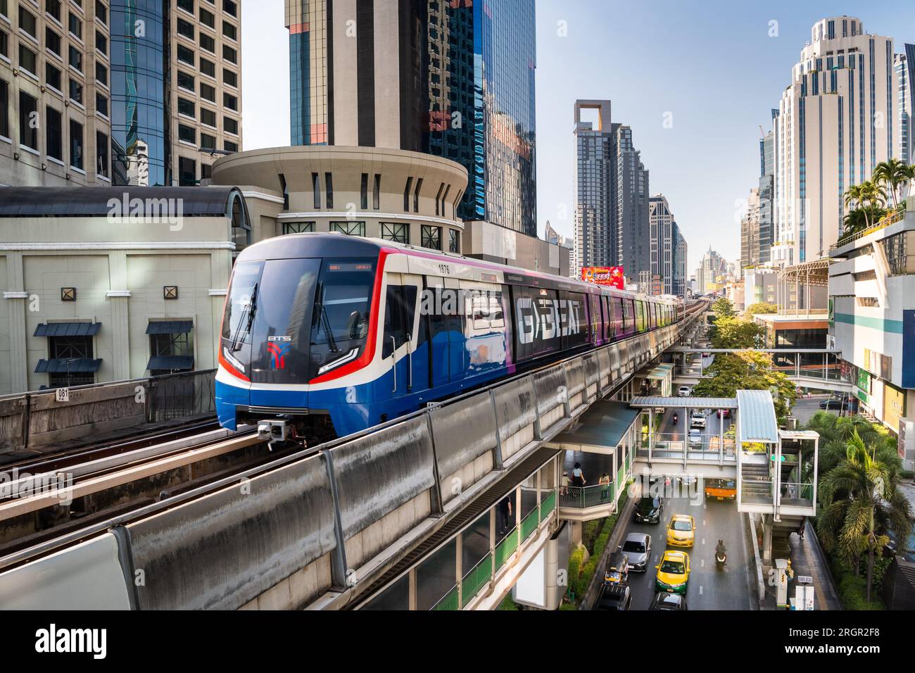 Sky trains come and go high above Sukhumvit Rd. at Asoke BTS sky train ...