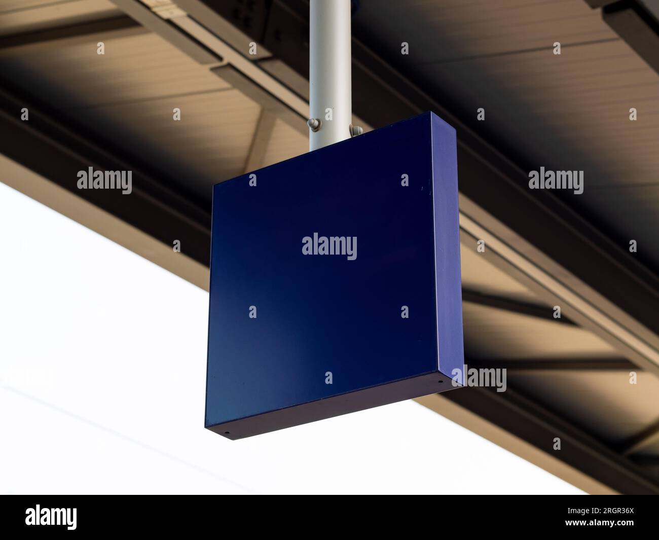 Empty blue sign hanging from the rooftop in a public area. The squared ...