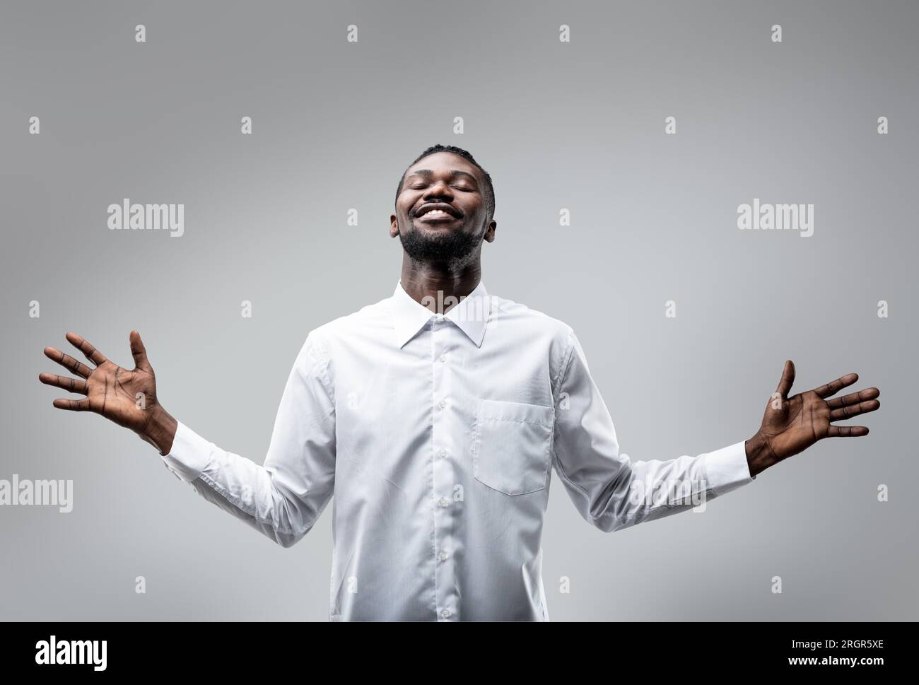 Man in white shirt opens arms wide, expressing gratitude, satisfaction ... Man in white shirt opens arms wide, expressing gratitude, satisfaction ...