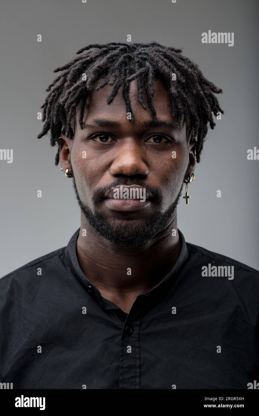 Frontal portrait of a black man with short braided hair covering his ...