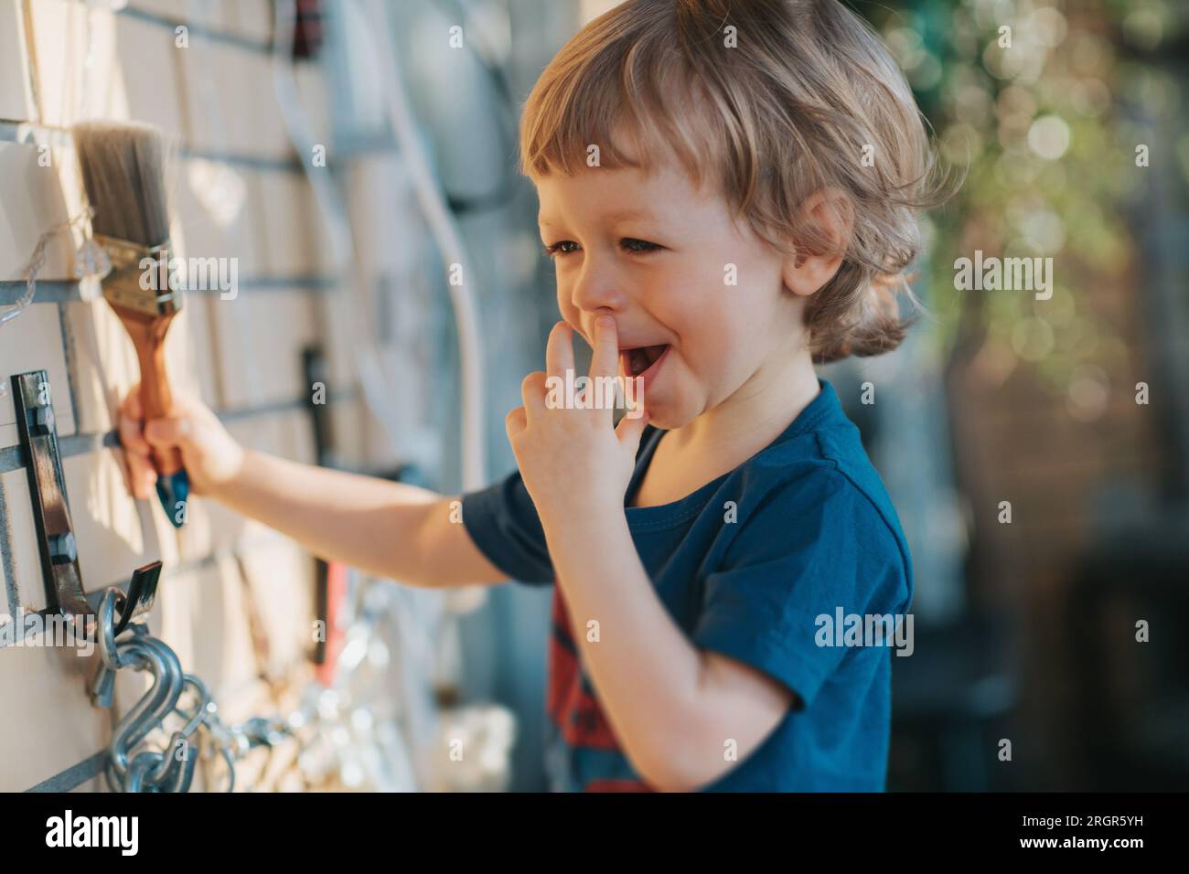 A fun little kid playing with work tools Stock Photo - Alamy