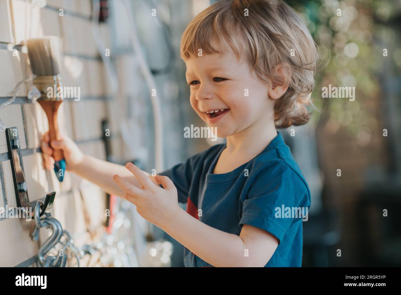 A fun little kid playing with work tools Stock Photo - Alamy