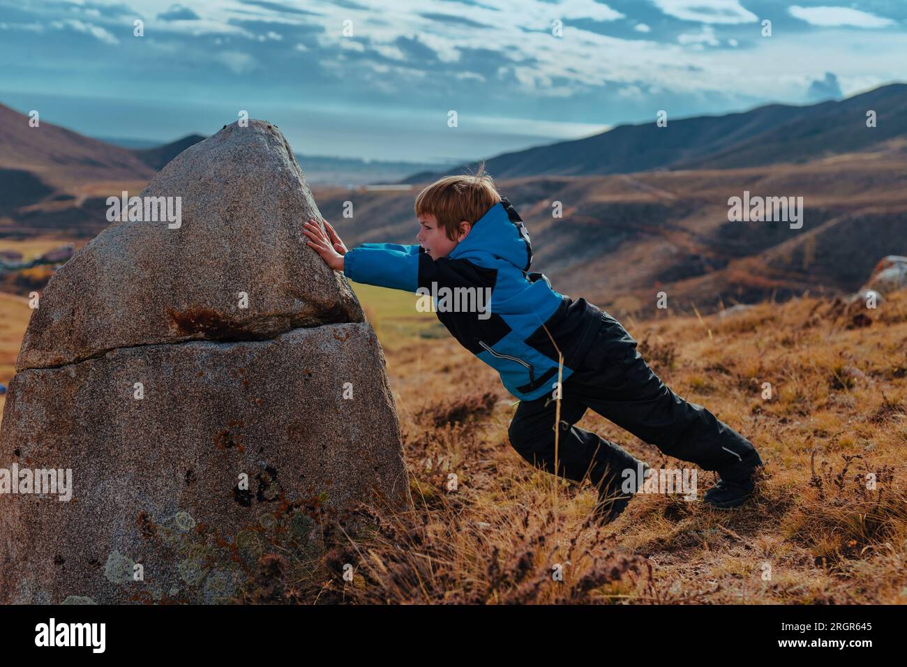 Boy pushing rock hi-res stock photography and images - Alamy