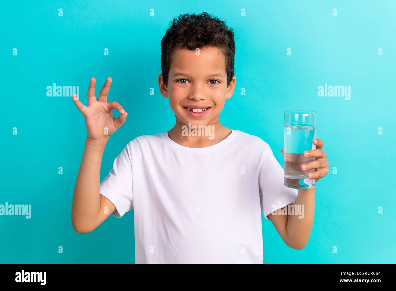 Photo of small charming schoolchild toothy smile hold mineral water ...