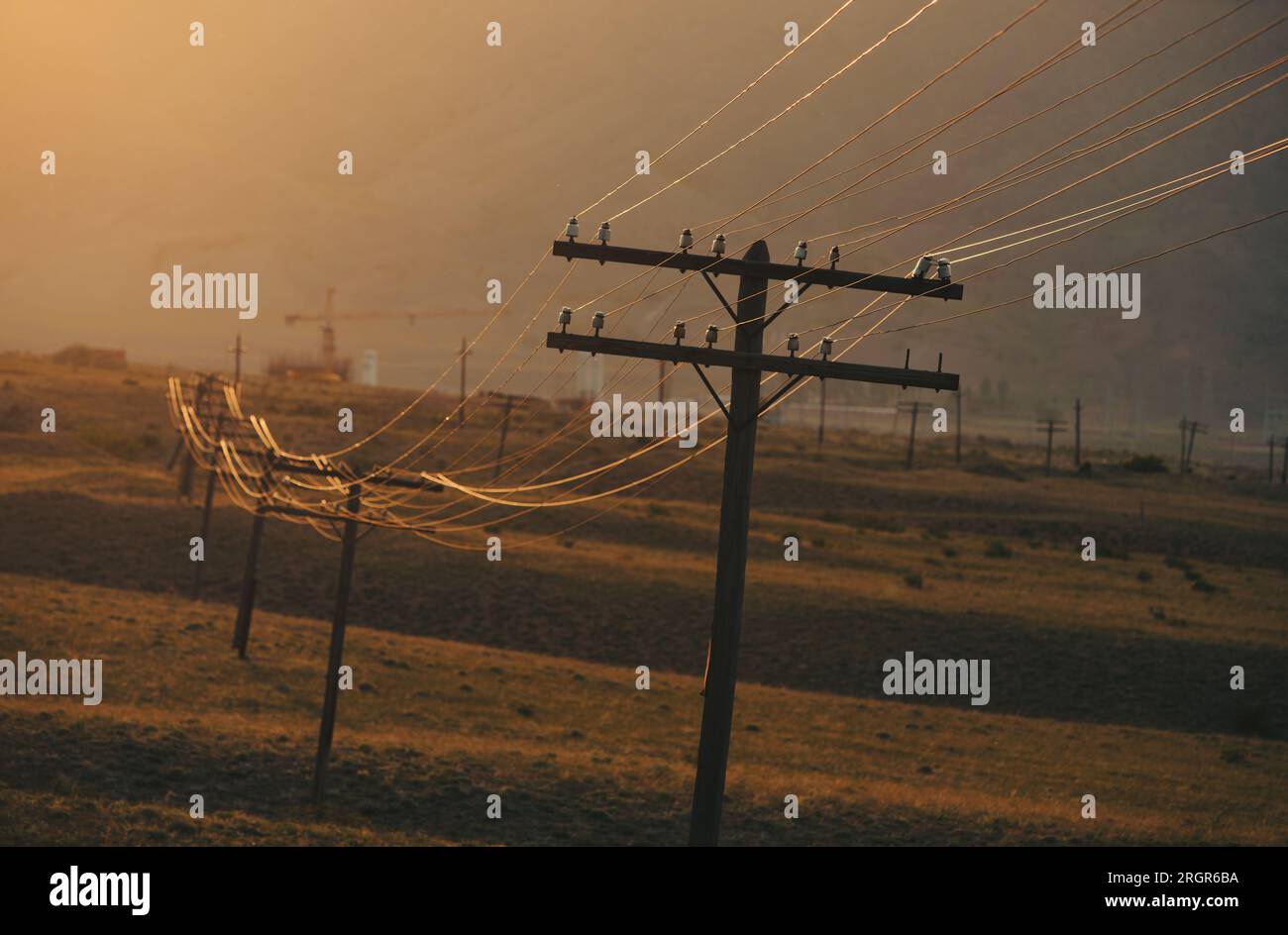 Electric power lines at warm sunset light Stock Photo - Alamy