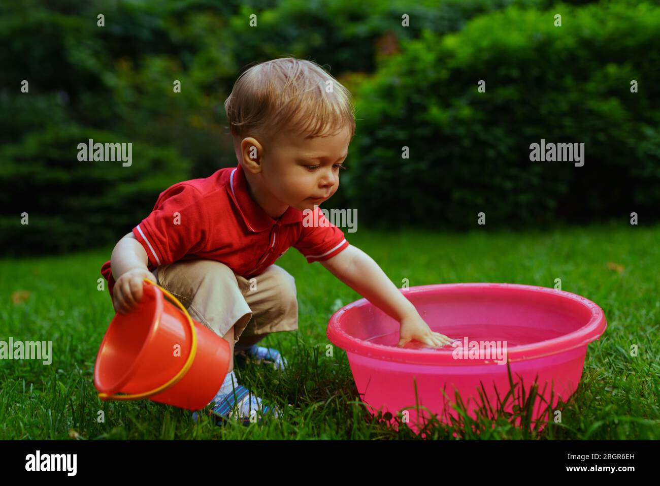 Child playing with bucket of water hi-res stock photography and images ...