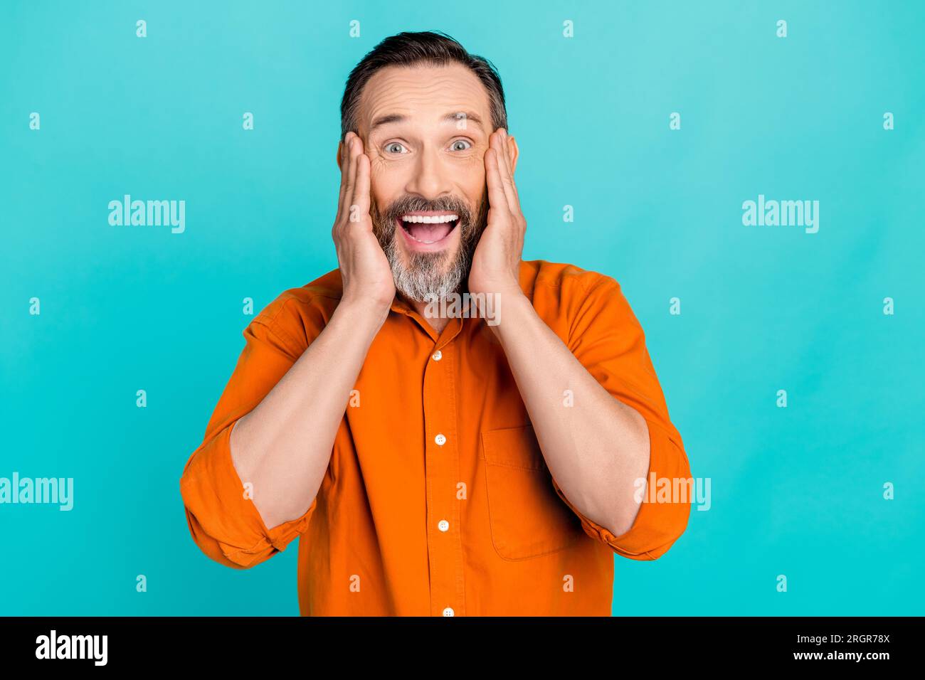 Photo of shocked excited man dressed orange shirt arms cheeks open ...