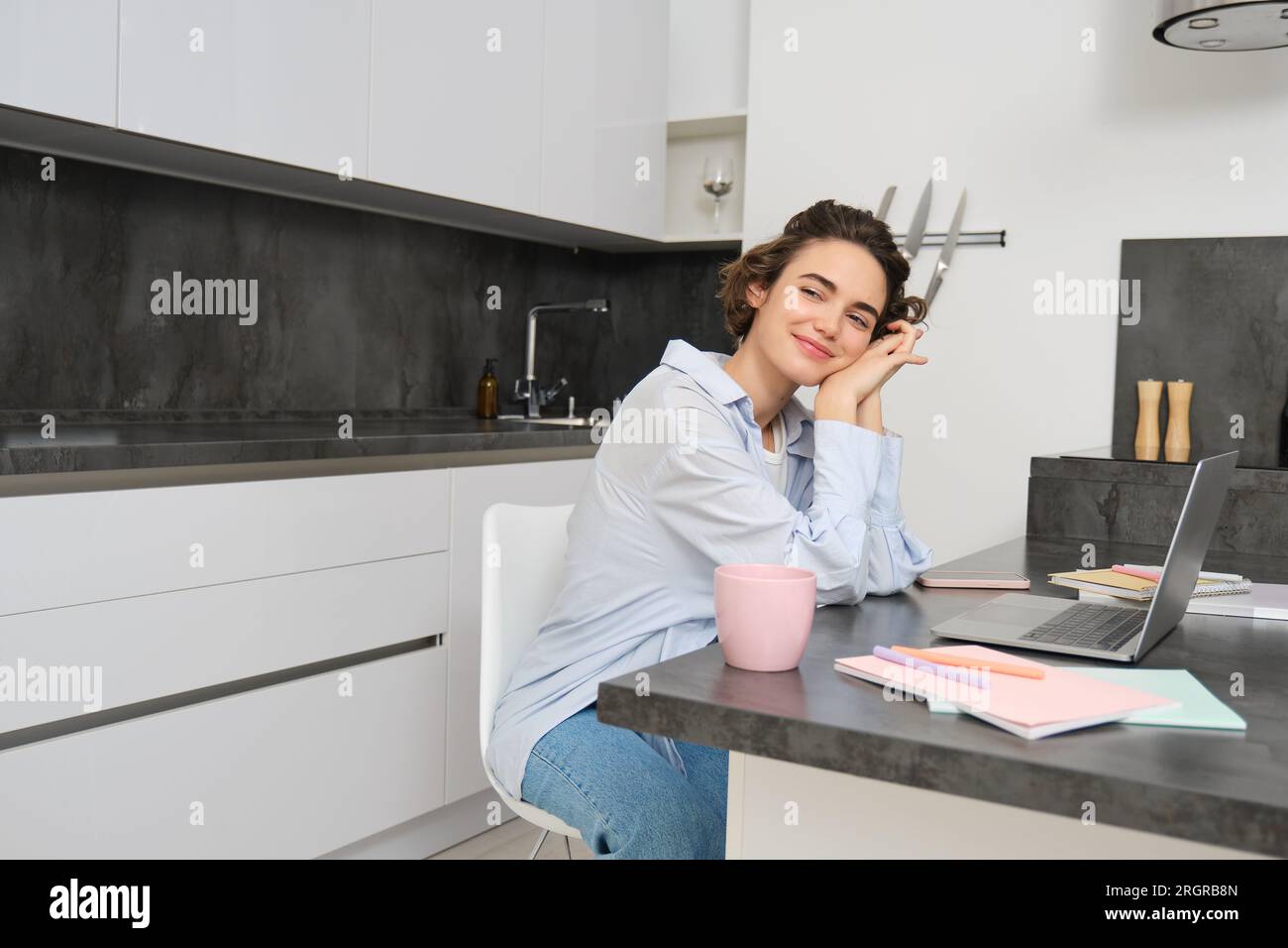 Beautiful brunette woman, looking outside window, working from home ...