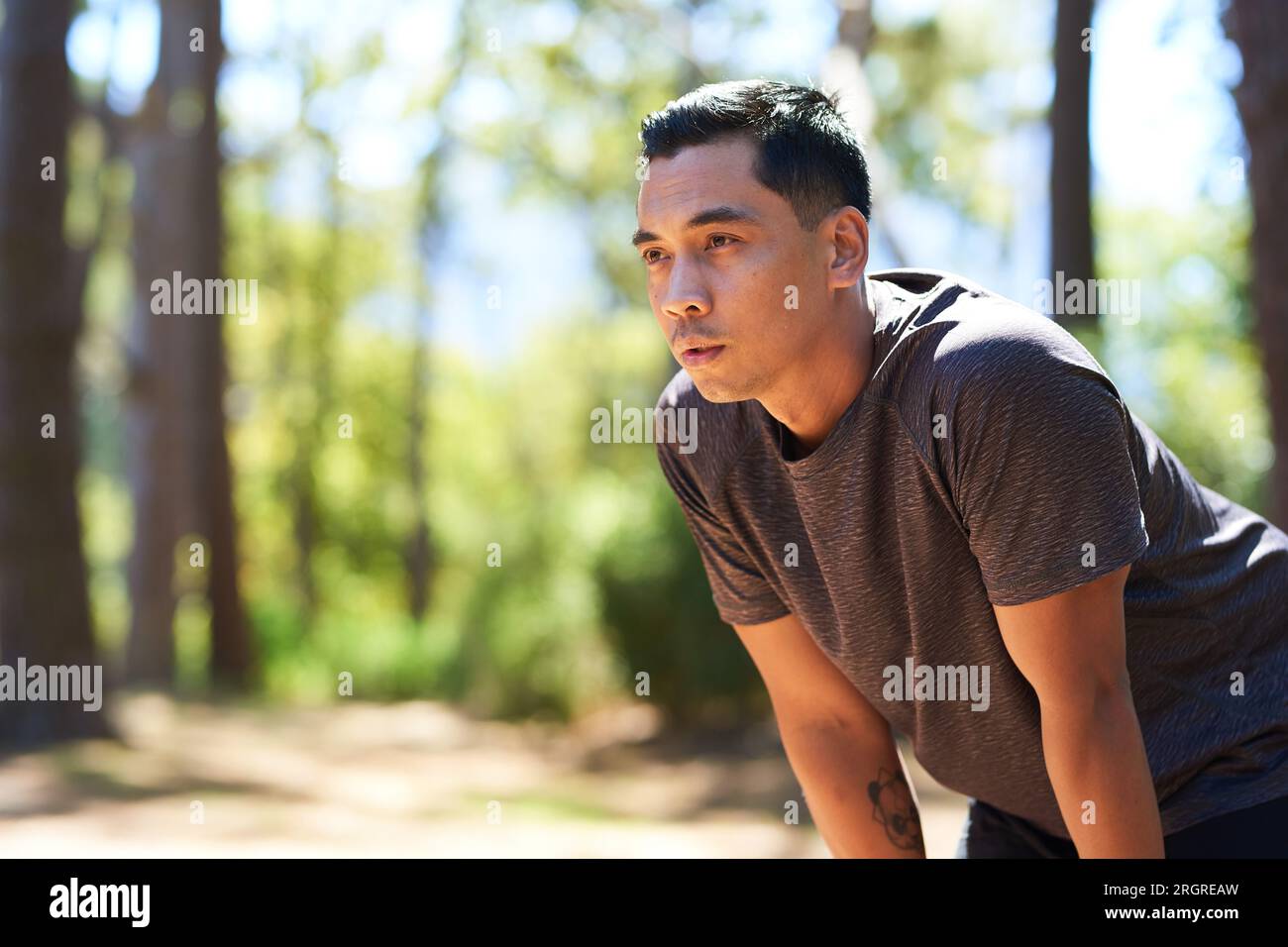 Tired and sweaty Asian man takes a break while trail running, breathing Stock Photo - Alamy