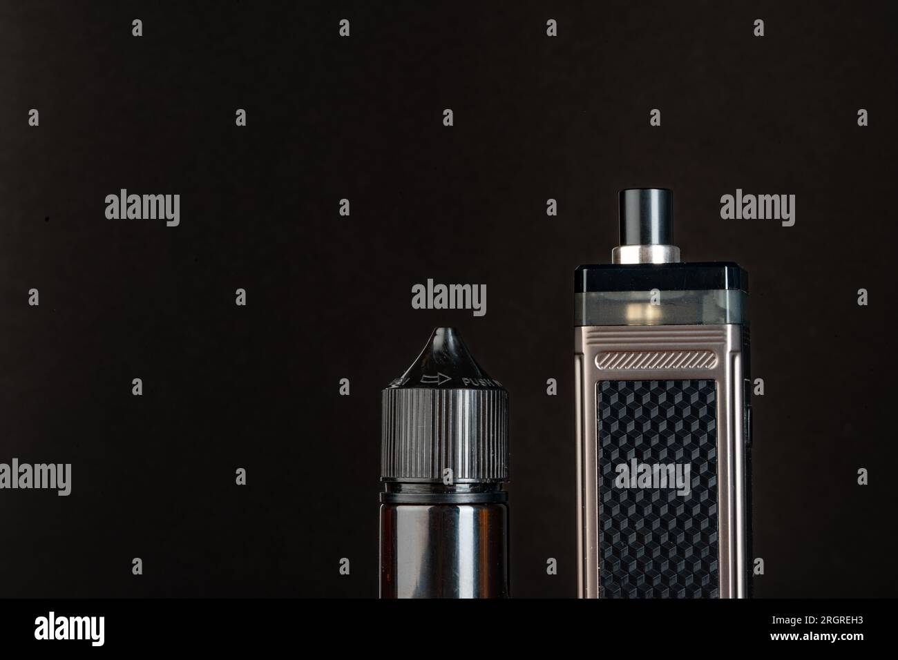Vape and vape liquid bottles against black background Stock Photo - Alamy