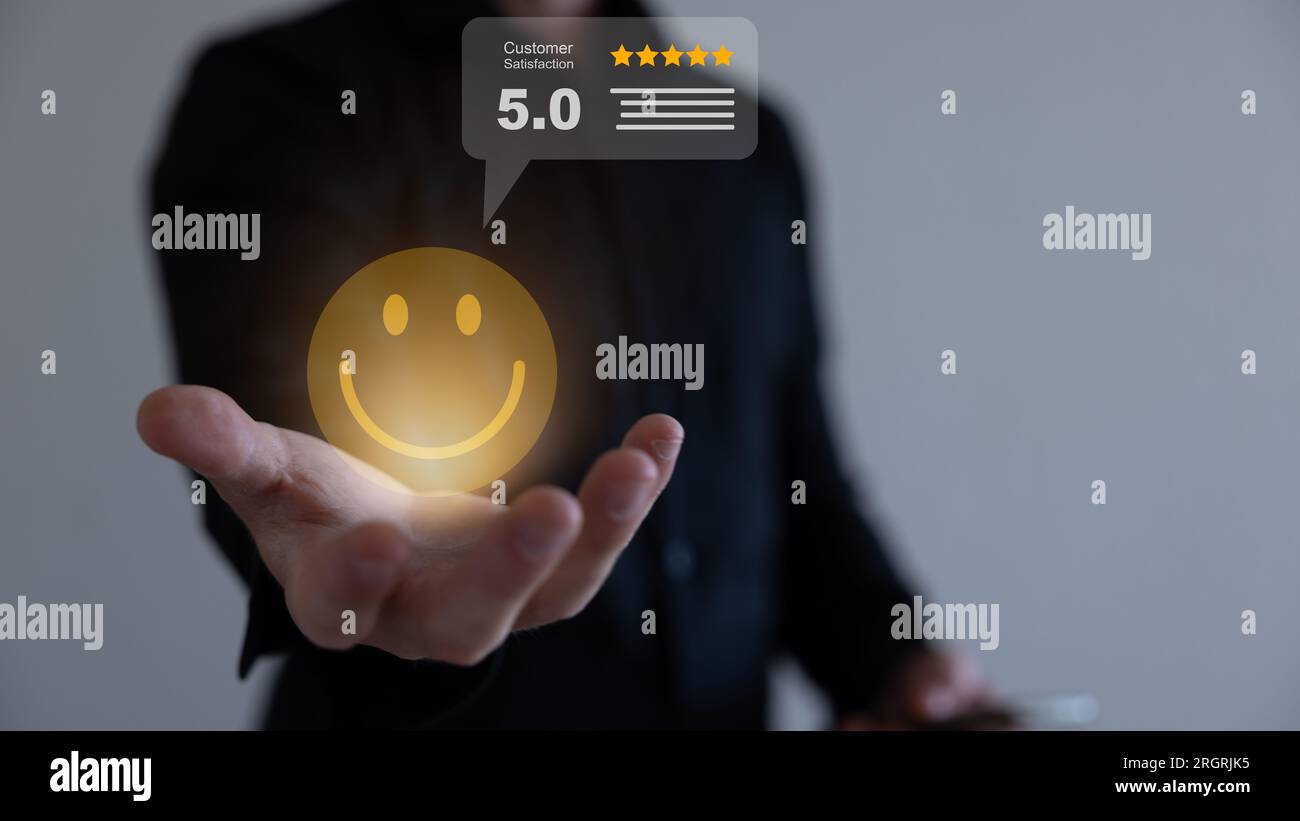 Businessman holding virtual smiley face with five stars and using ...