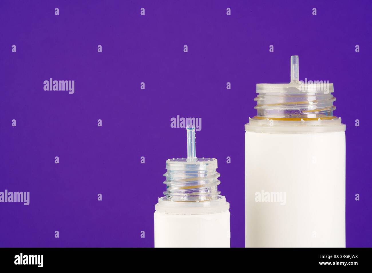Vape liquid dripping with cap on purple background Stock Photo - Alamy