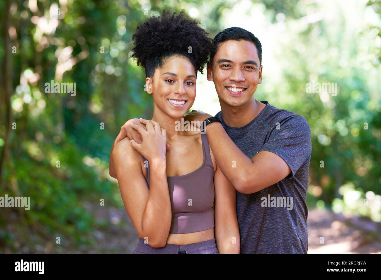 Happy young couple pose in forest in active wear, fitness trail run ...