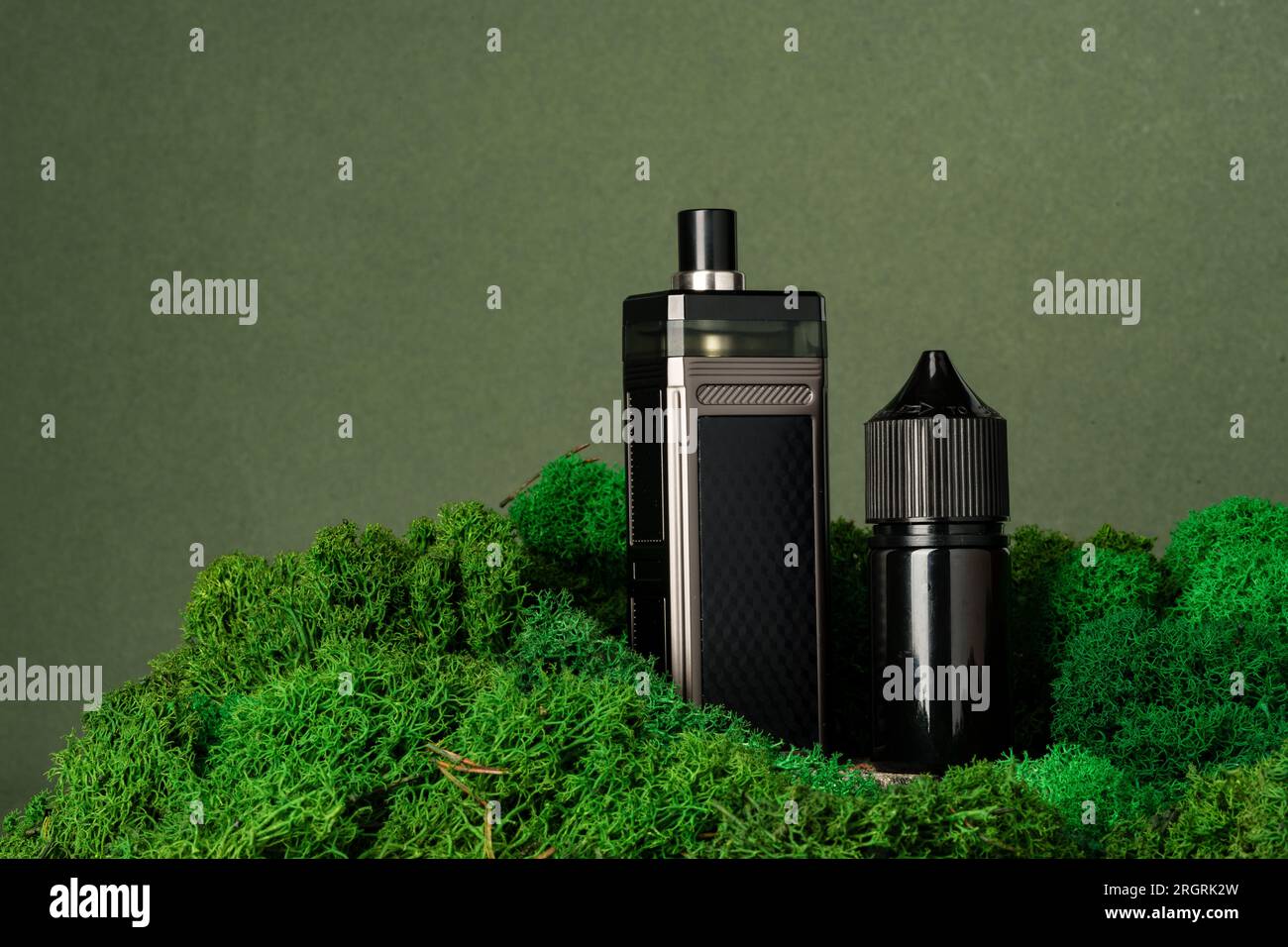 Vape smoking liquid bottles on moss background Stock Photo - Alamy
