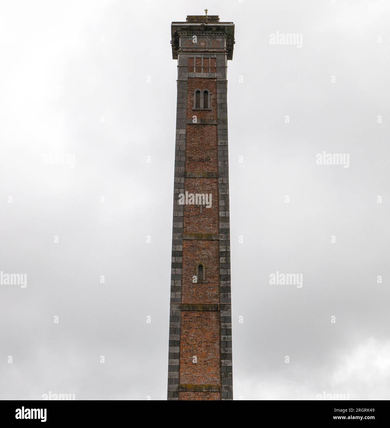 High brick tower construction over white background Stock Photo - Alamy
