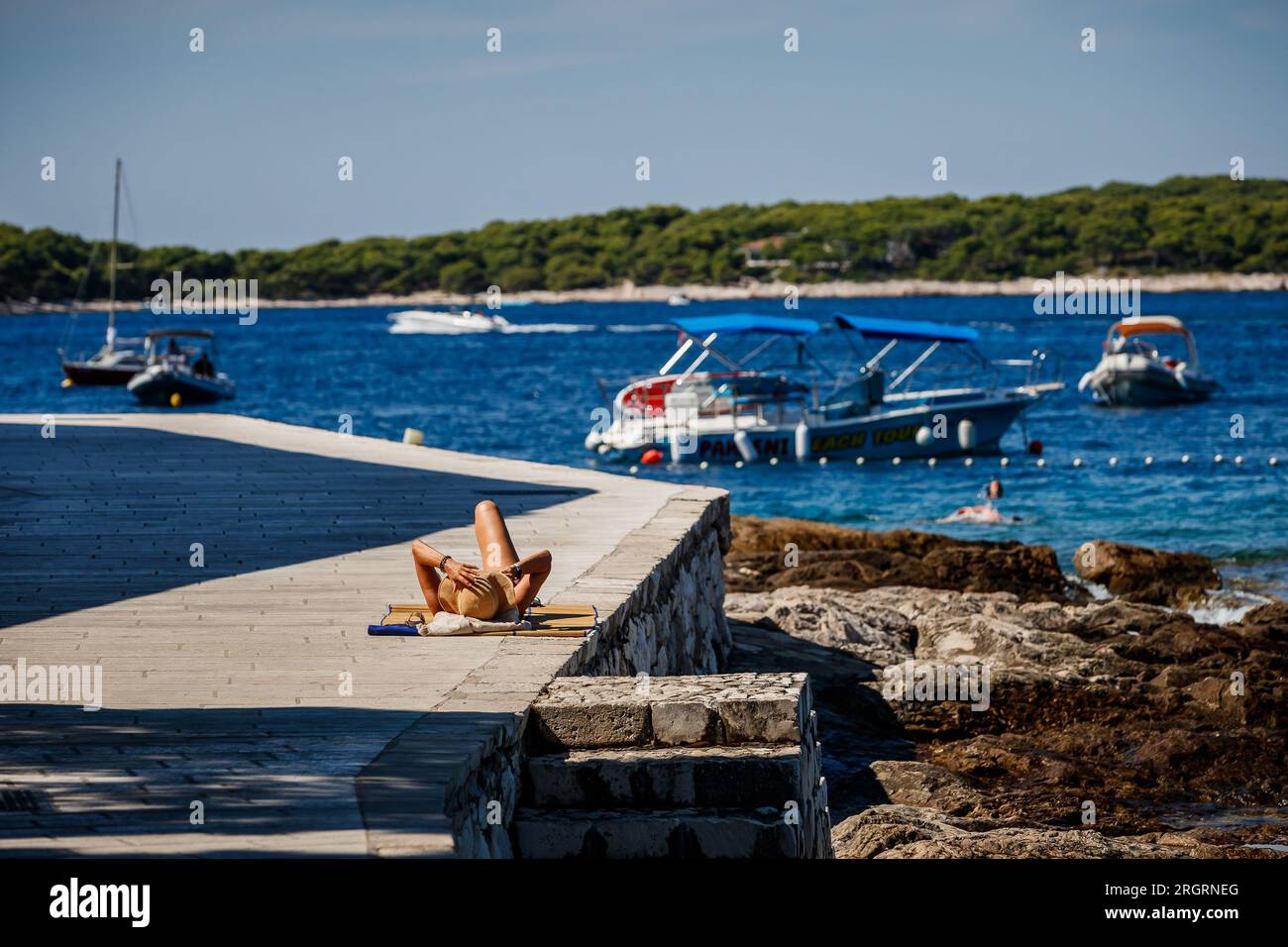 Split, Croatia. 11th Aug, 2023. Woman sunbathes at the beach Lucica at ...