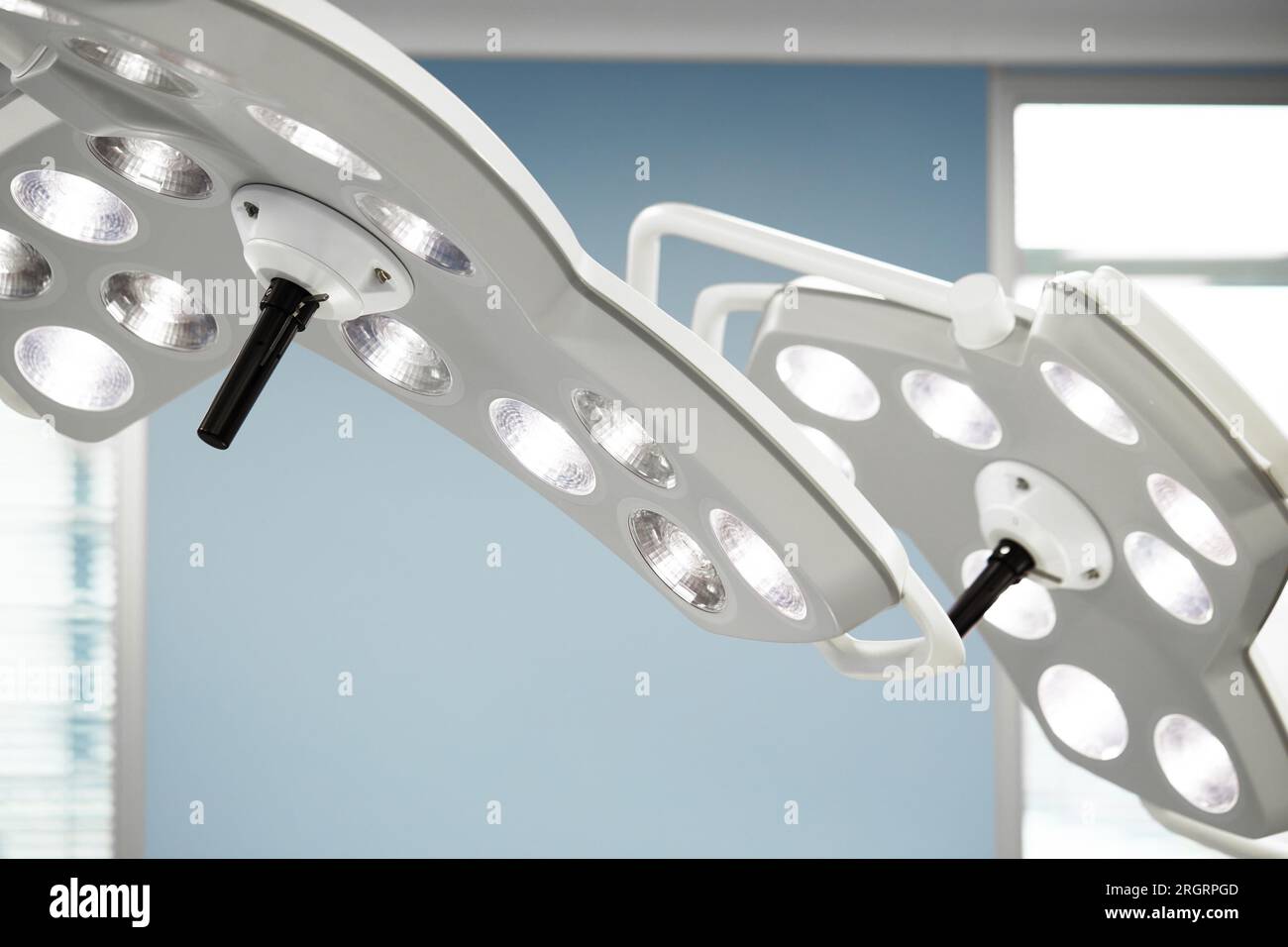 Two surgical lamps in operation room. Blue cast light represent purity ...